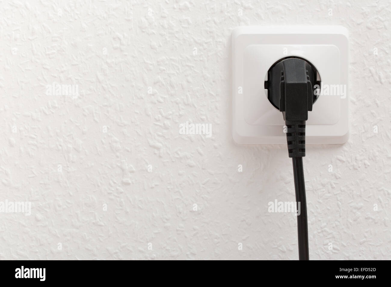 Single electric socket with plug on white wall Stock Photo - Alamy