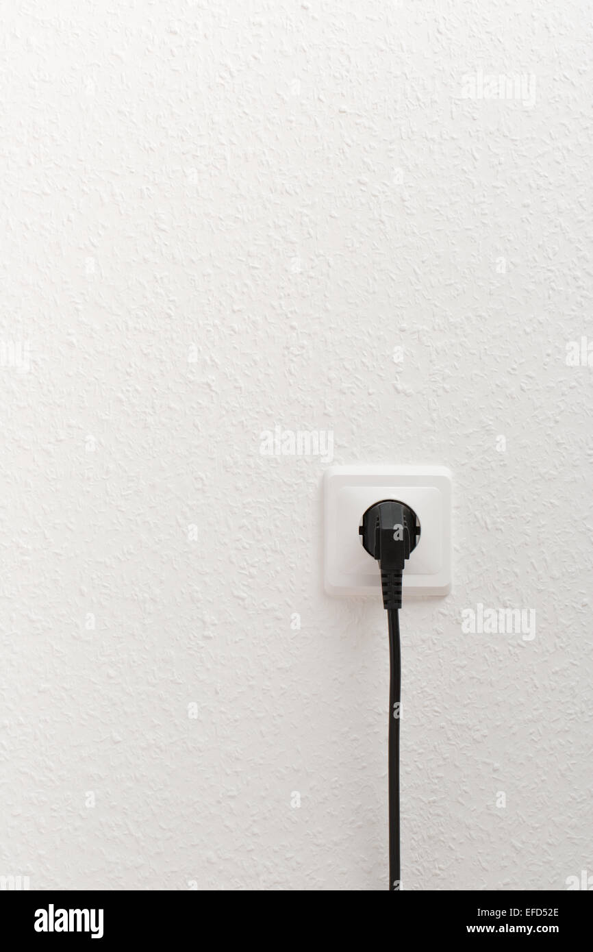 Single electric socket with plug on white wall Stock Photo - Alamy