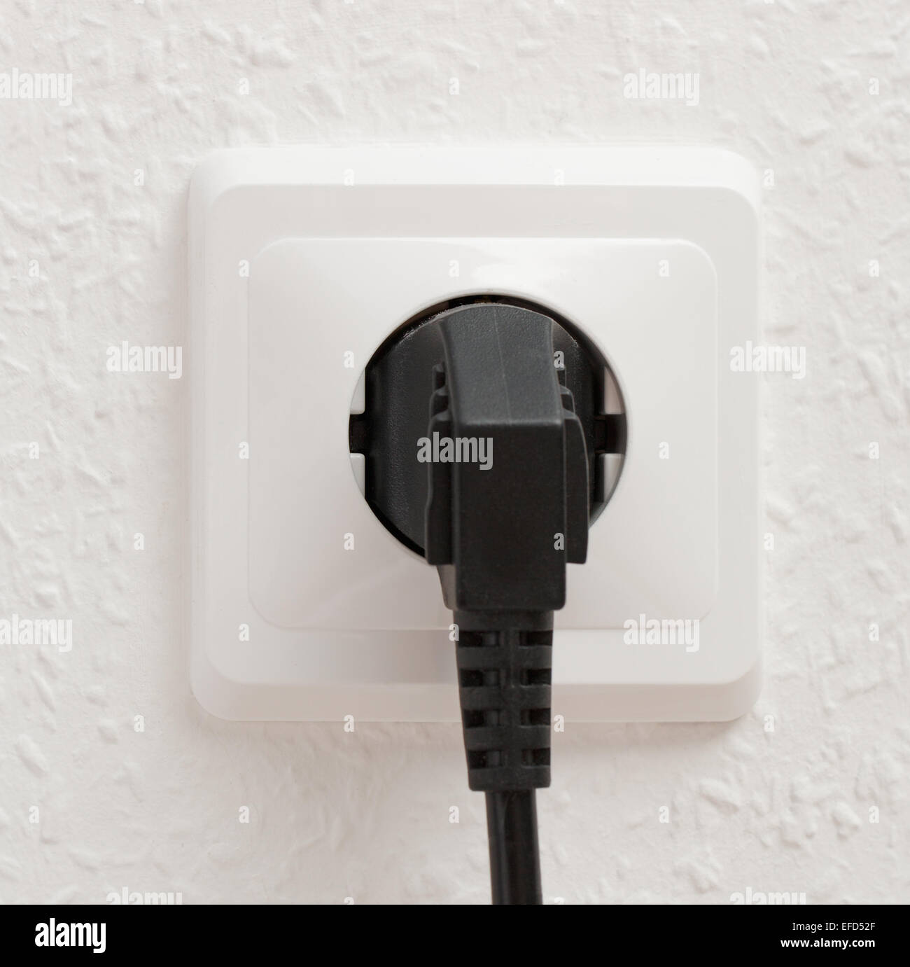 Single electric socket with plug on white wall Stock Photo - Alamy