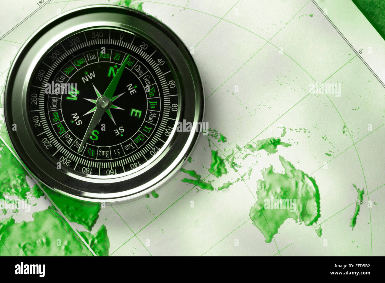 Compass on map background in green toning Stock Photo - Alamy