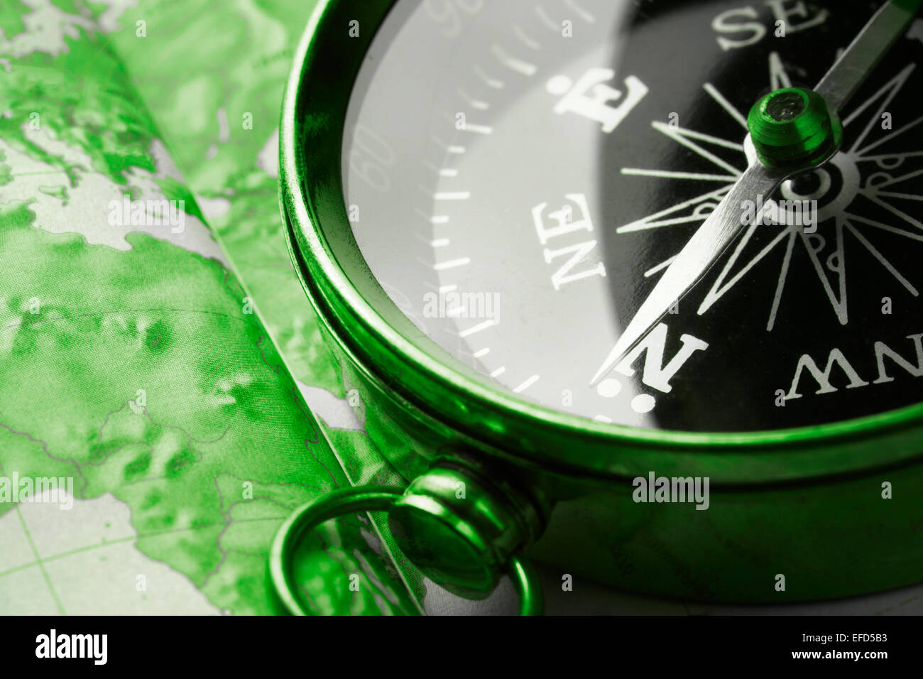 Compass on map background in green toning Stock Photo - Alamy