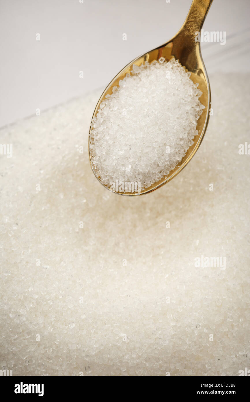 Heap of white sugar and golden spoon Stock Photo - Alamy