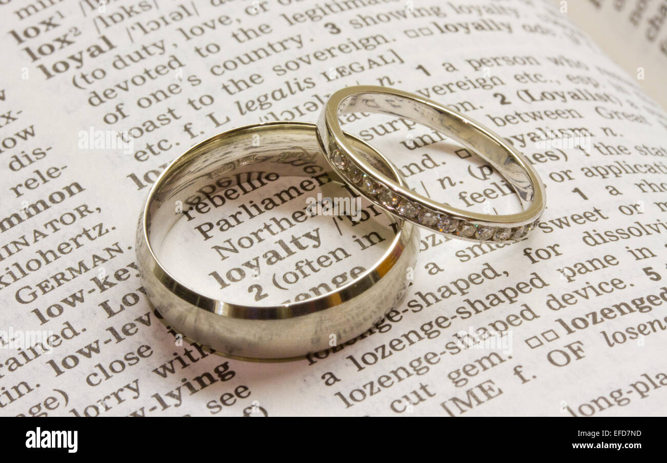 Wedding rings depicting word loyalty Stock Photo - Alamy