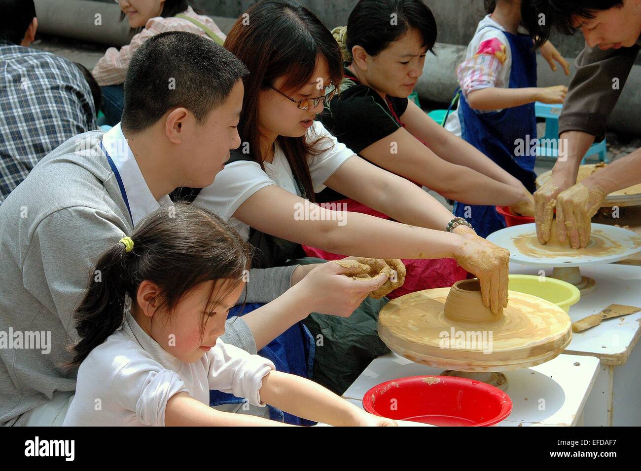 Chengdu, China: Students seated on stools using potters wheels learn ...
