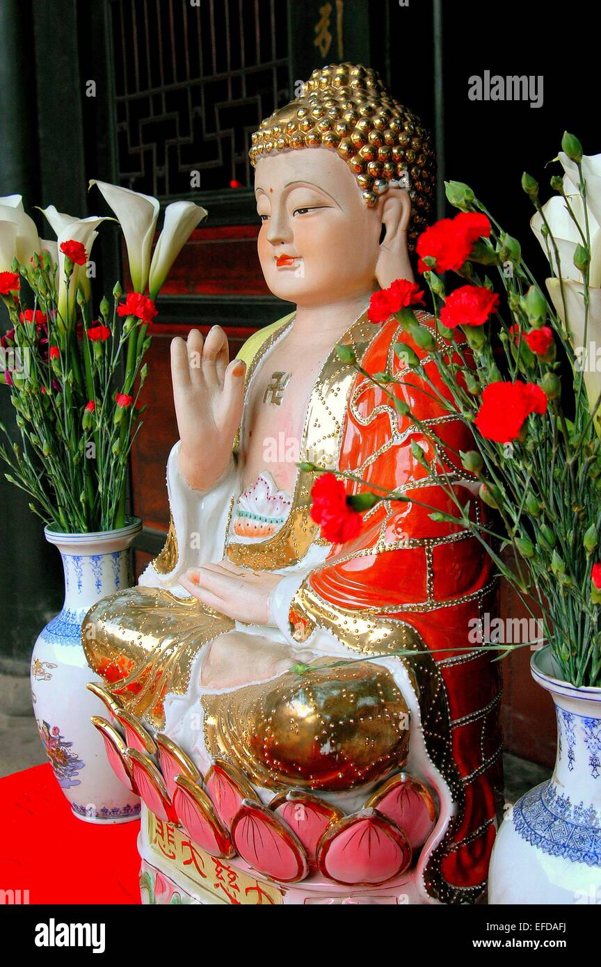 Chengdu, China: Statue of a Buddha with upraised hand surrounded by ...