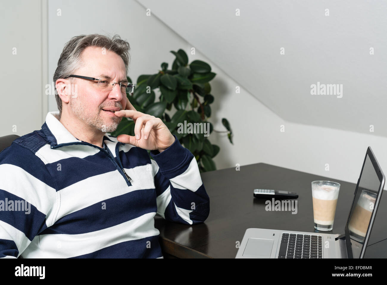 Man working from home on laptop computer Stock Photo - Alamy