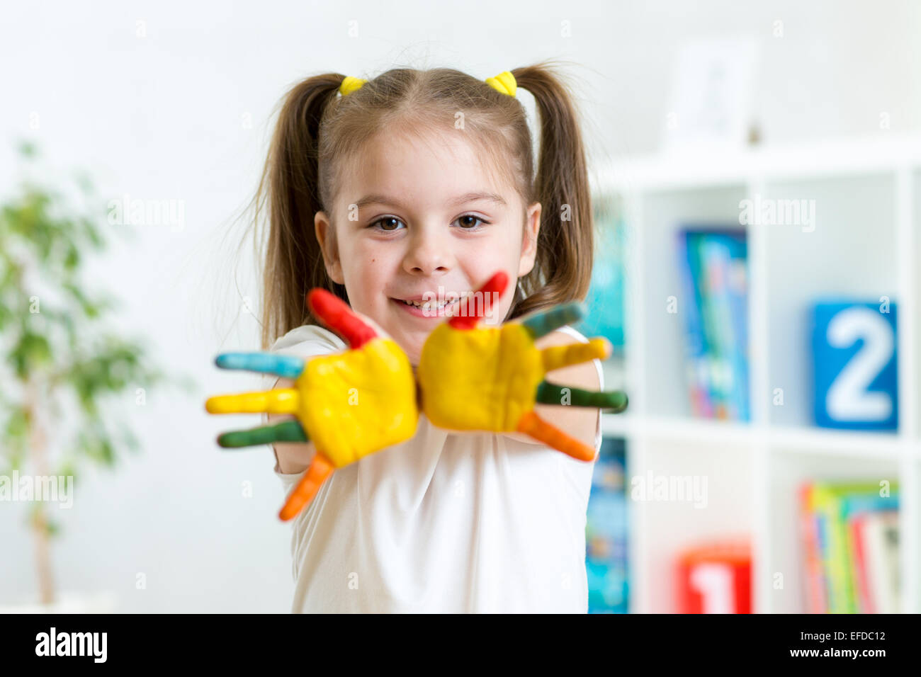 little girl with hands in paint on nursery background Stock Photo - Alamy