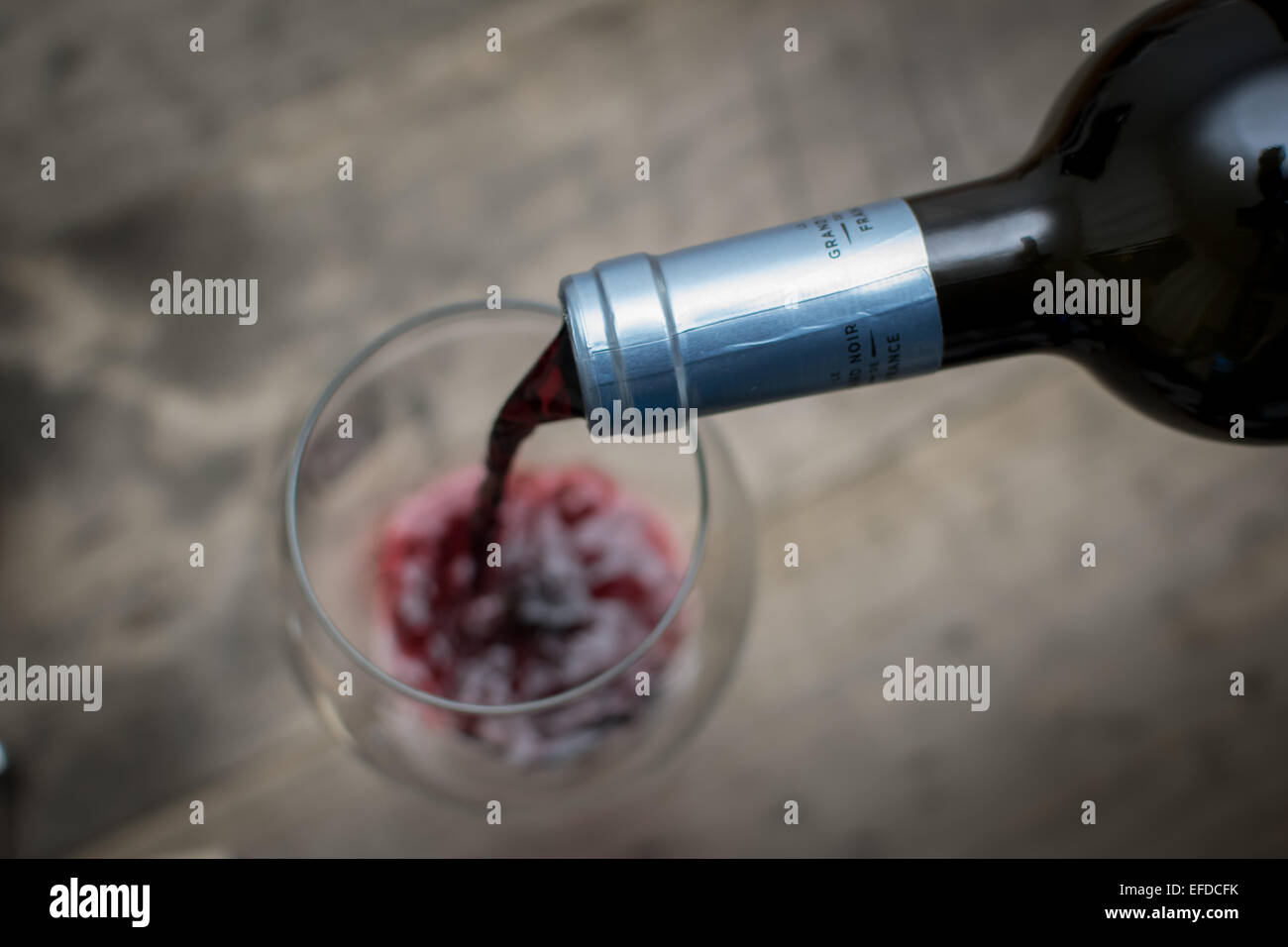 Pouring Red Wine - Focus on the Bottle Stock Photo - Alamy