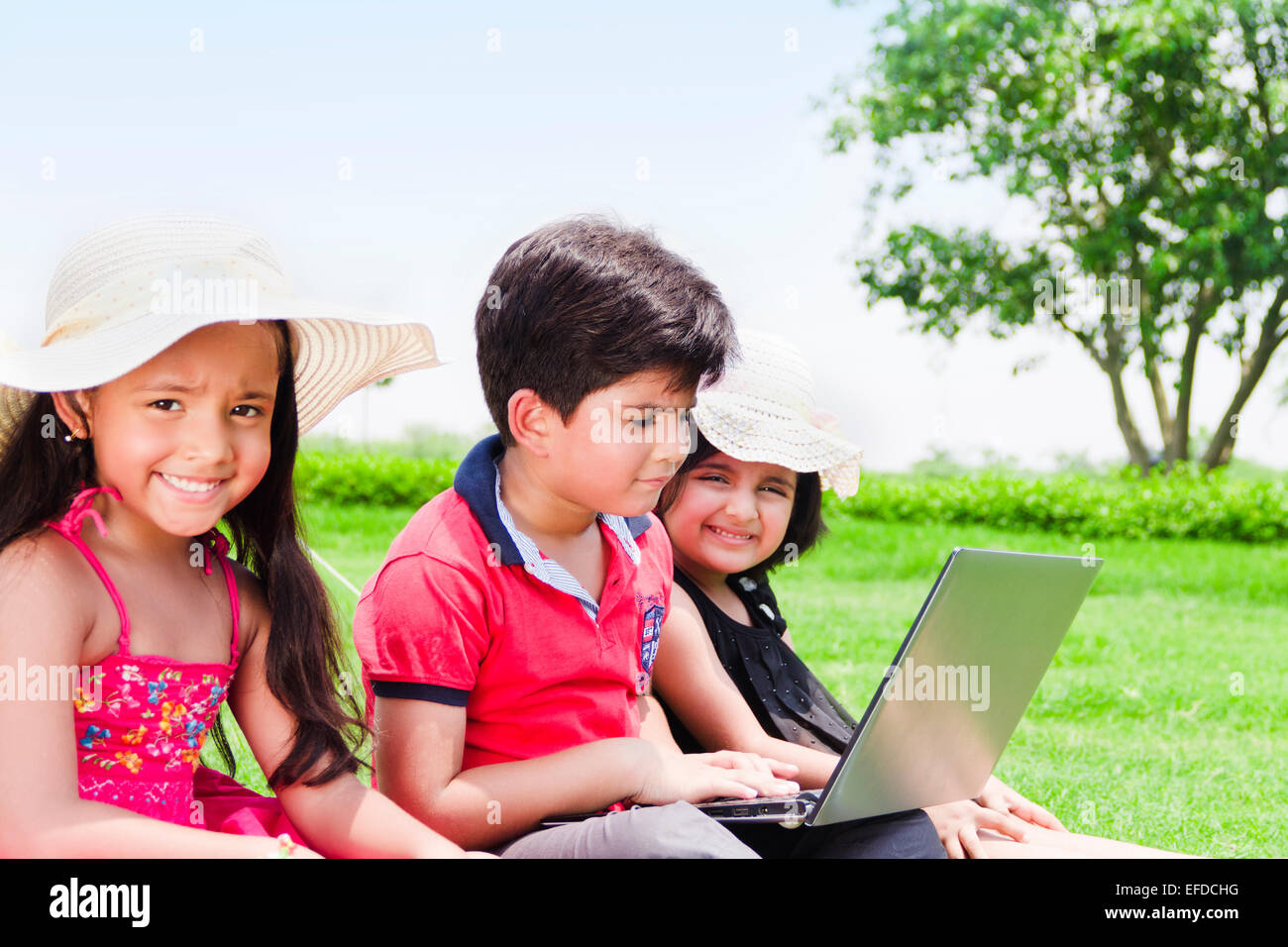 indian children friends park laptop working Stock Photo - Alamy