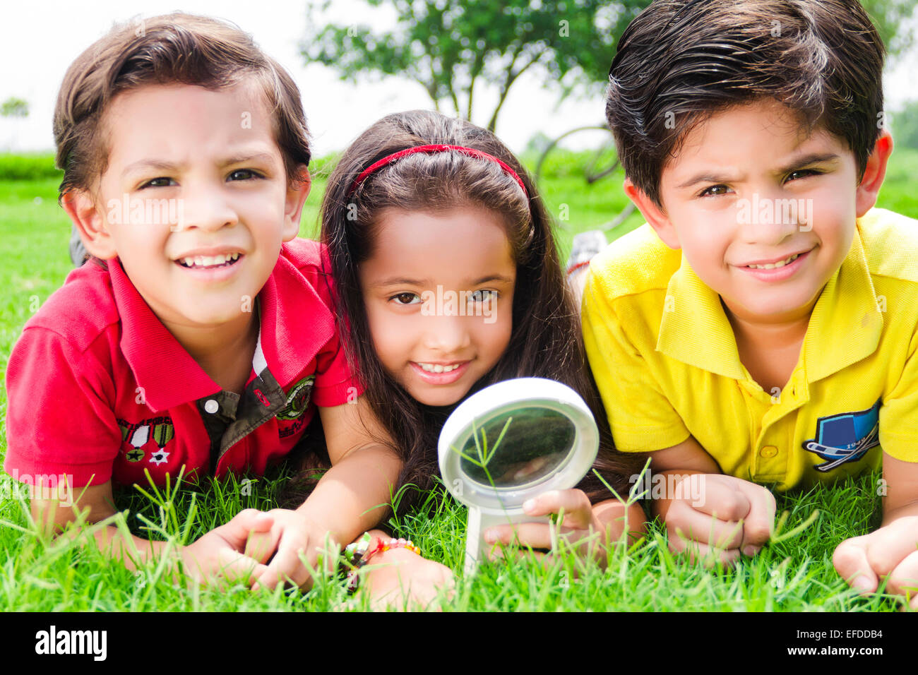 3 indian children friends park Magnifying Glass Searching Stock Photo ...