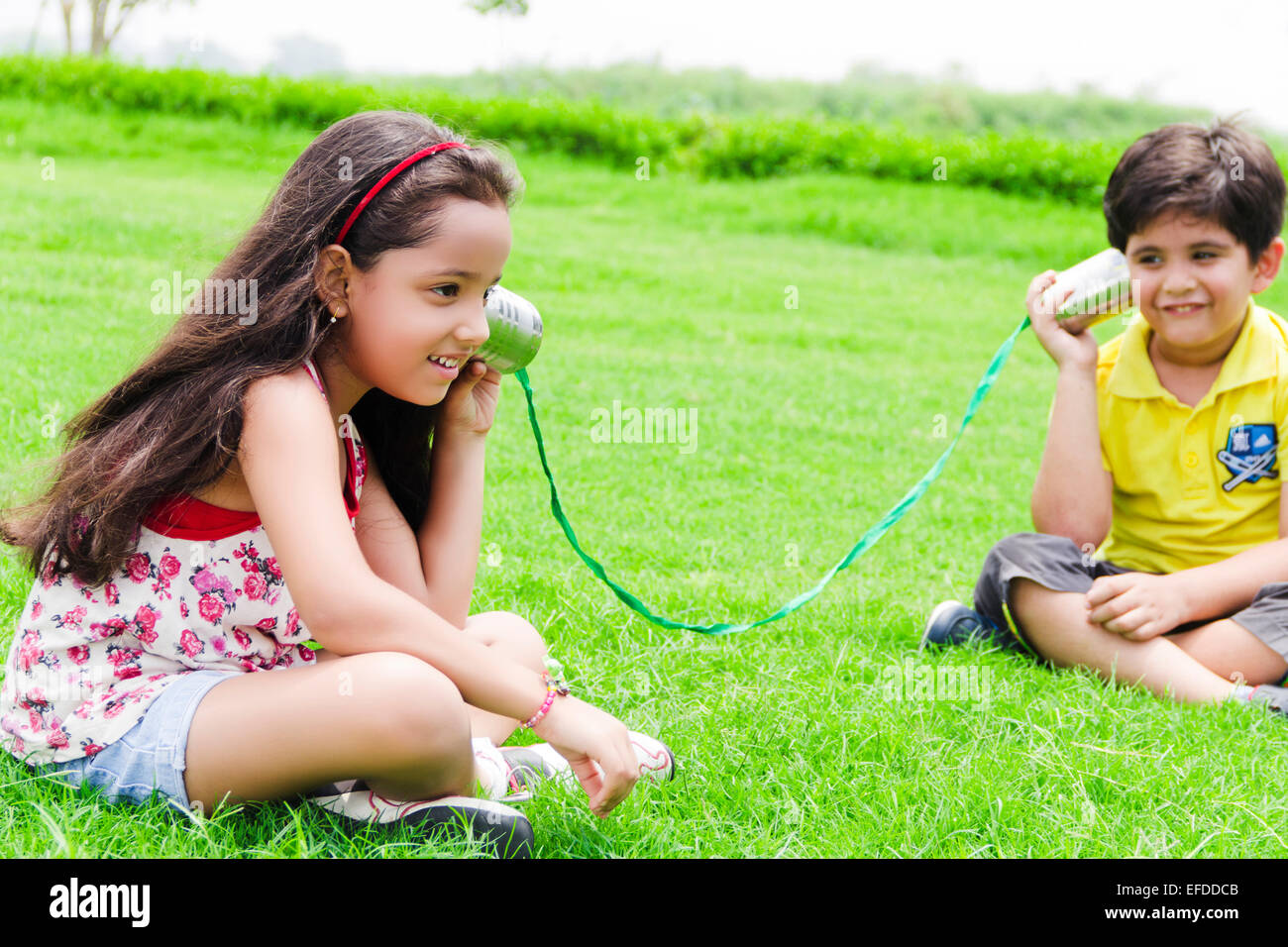 2 indian children friend park toy phone talking Stock Photo - Alamy