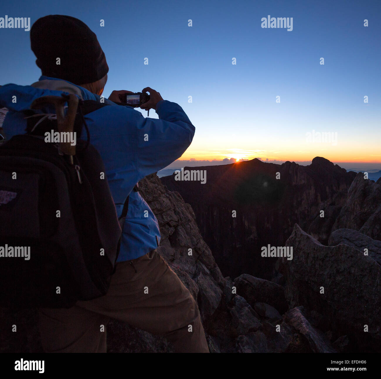 Climber photographing the sunrise peeping over Low's Gully from the ...