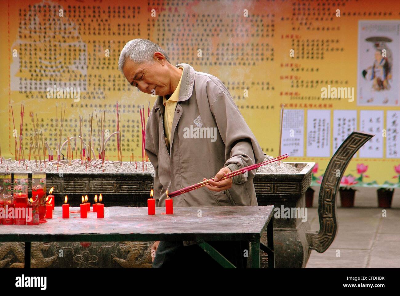 Chengdu, China: An elderly Chinese man lighting incense sticks from ...