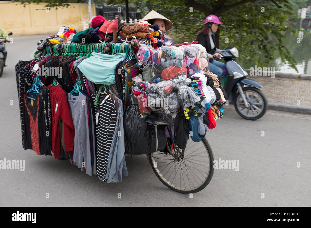 Street Vendor with Bicycle loaded with clothes for sale on the streets ...