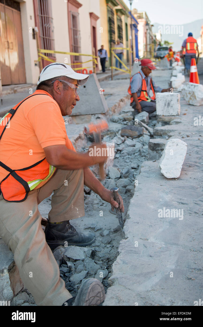 Oaxaca, Mexico - Workers use hammers and chisels to rebuild a ...