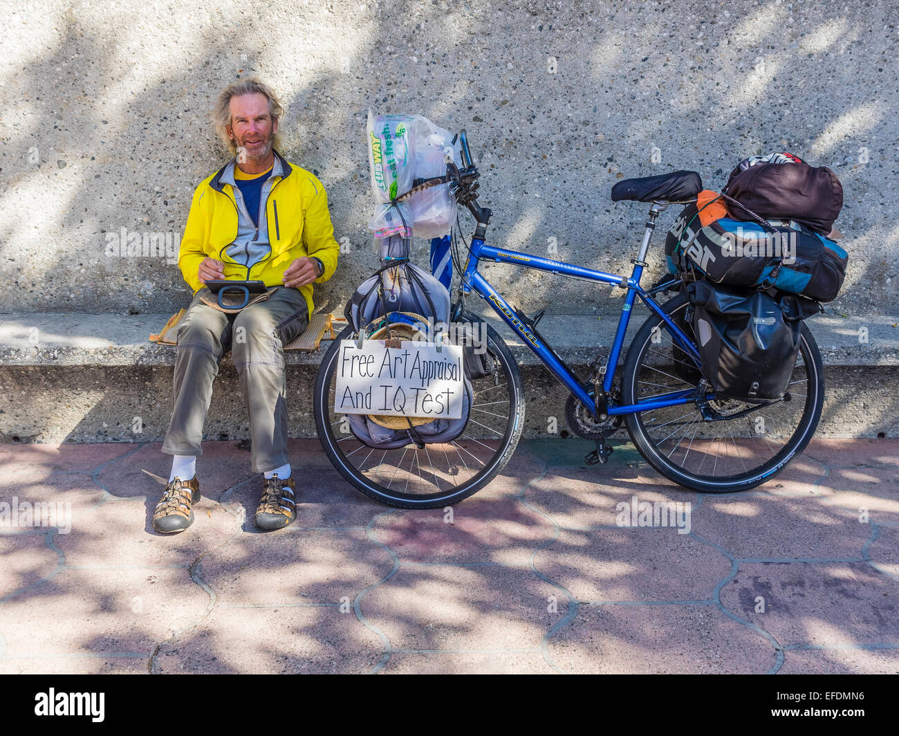 Kenneth Lock, a middle-aged homeless man, sits on a concrete bench with ...