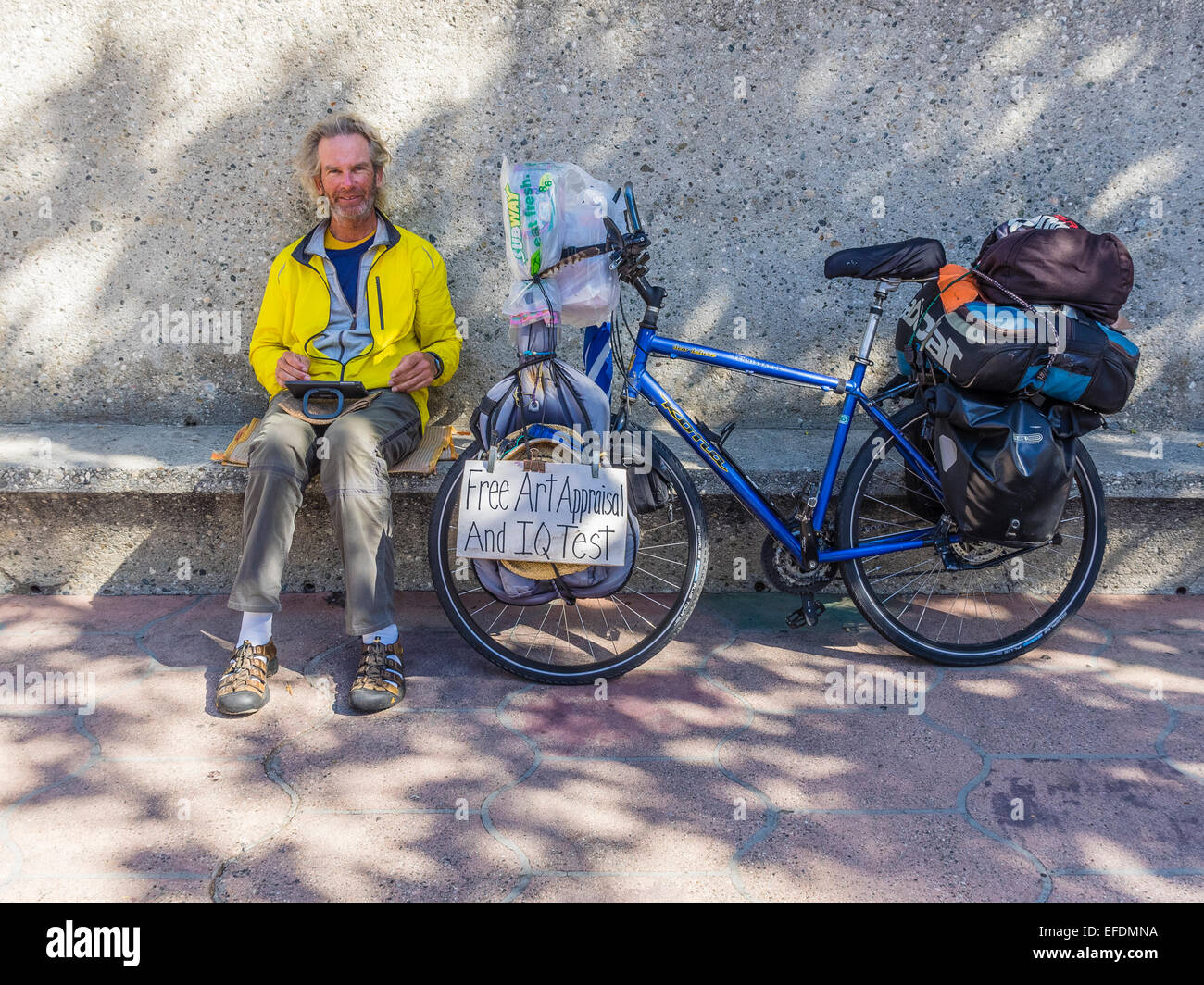 Kenneth Lock, a middle-aged homeless man, sits on a concrete bench with ...