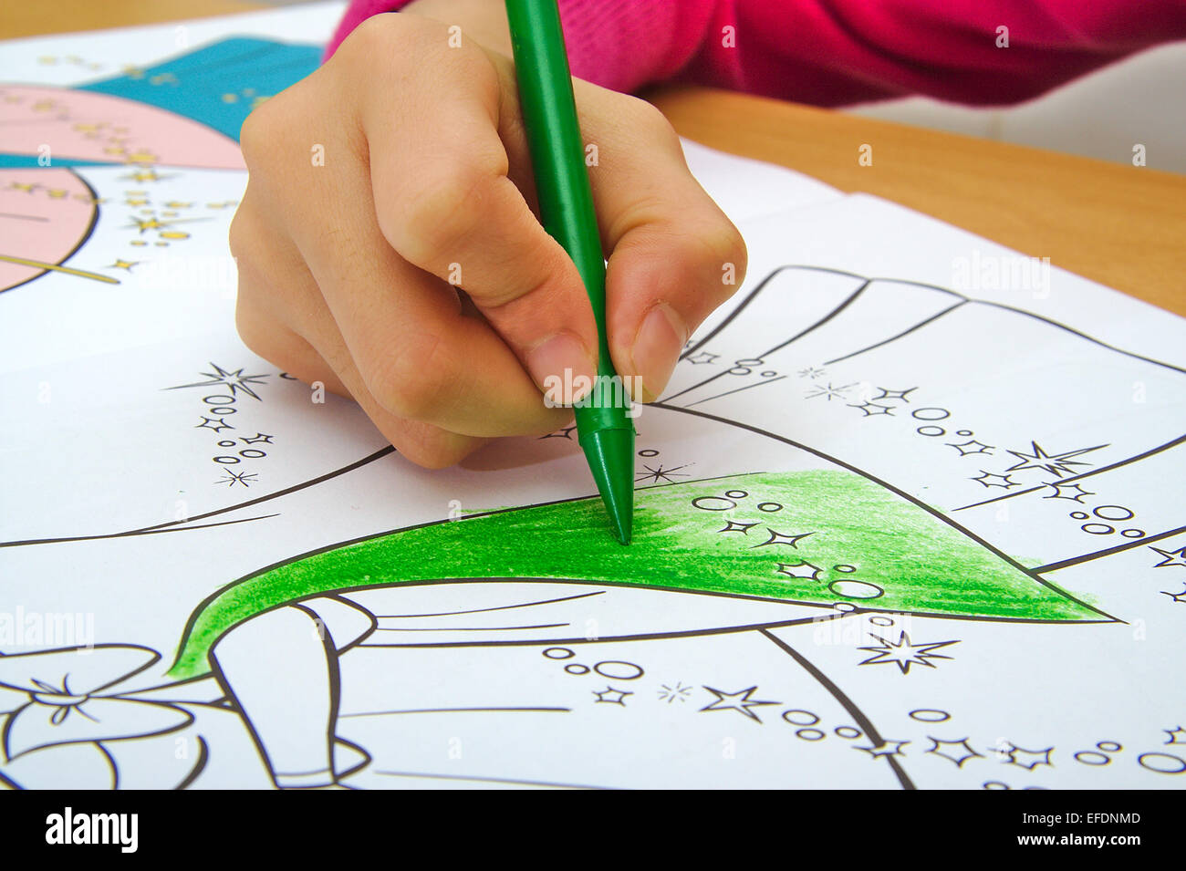 Girl drawing with a green crayon in classroom. School concept Stock ...
