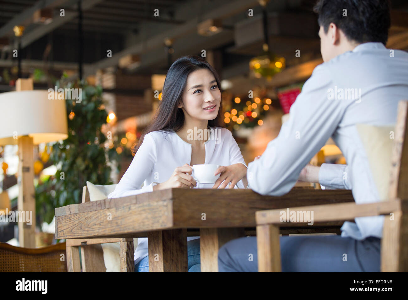 Young woman and man talking in cafe Stock Photo - Alamy