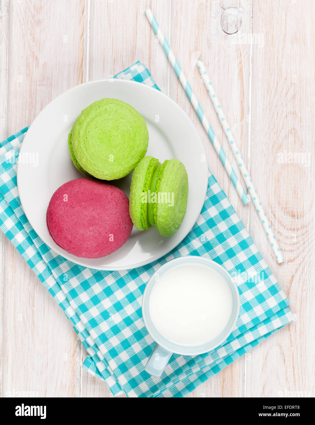 Colorful macarons and cup of milk on white wooden table Stock Photo - Alamy
