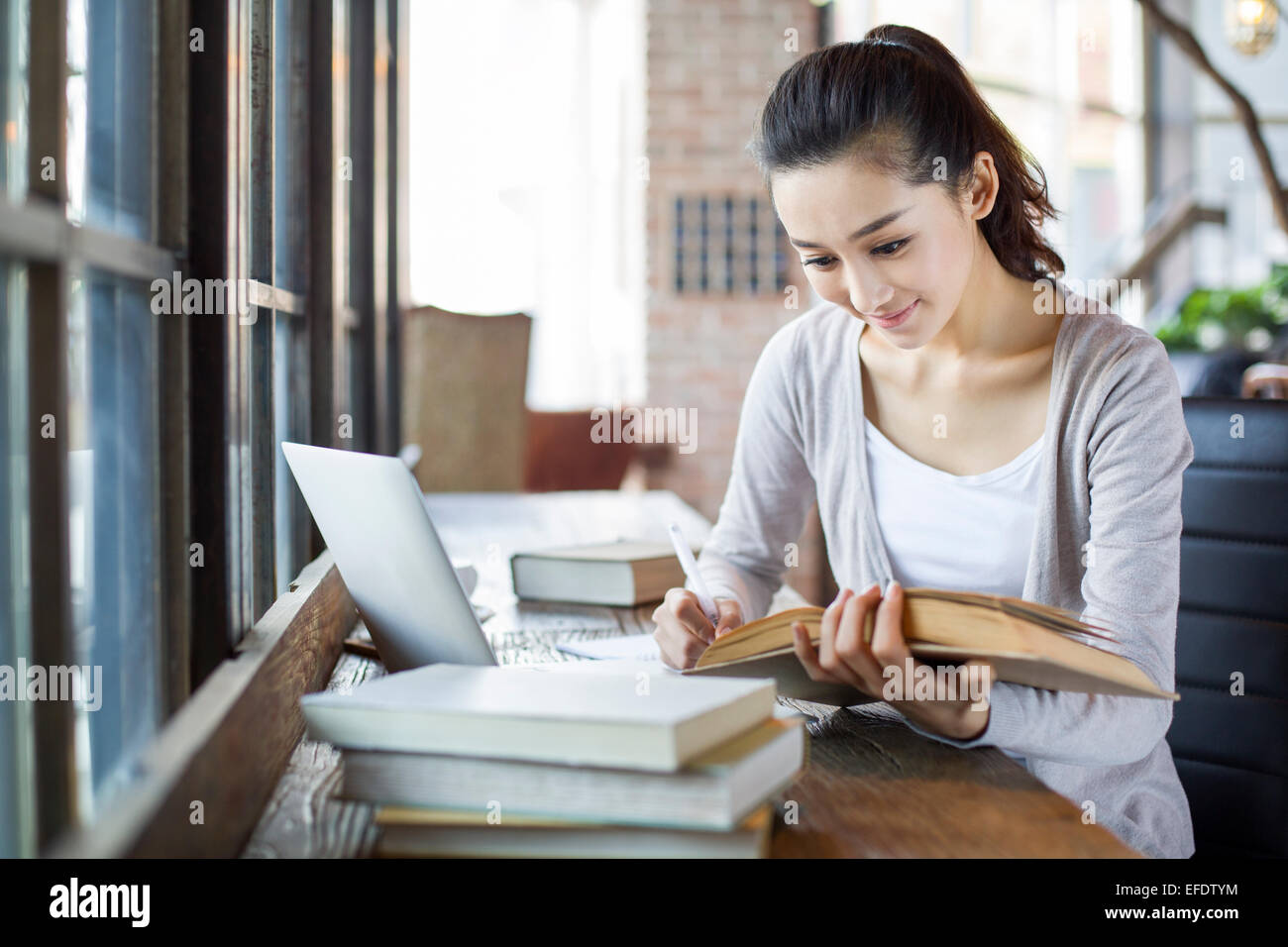 Young woman studying in cafe Stock Photo - Alamy