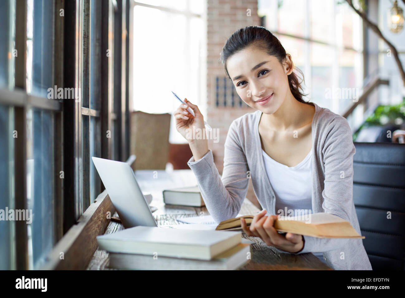 Young woman studying in cafe Stock Photo - Alamy