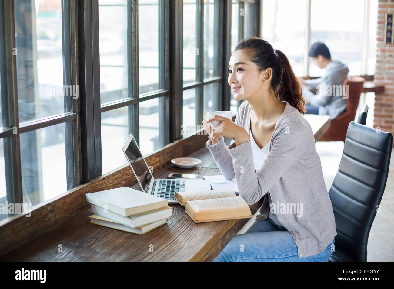 Young woman studying in cafe Stock Photo - Alamy