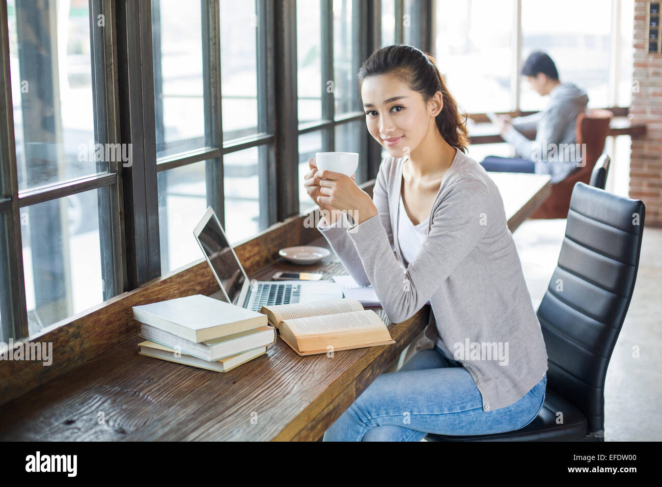 Young woman studying in cafe Stock Photo - Alamy