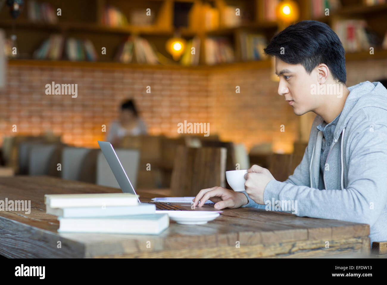 Young man using laptop in cafe Stock Photo - Alamy