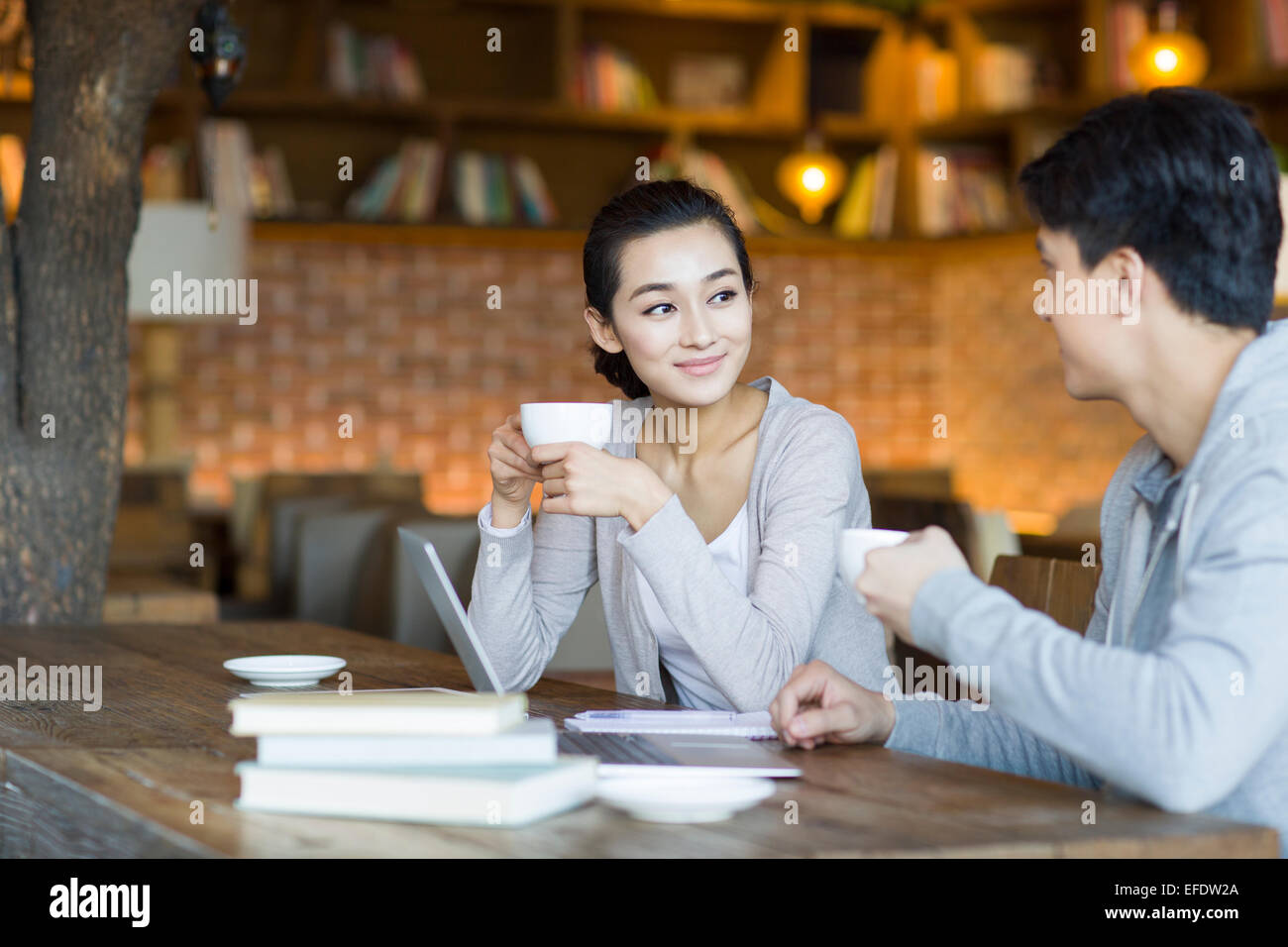 Young man and woman talking in cafe Stock Photo - Alamy