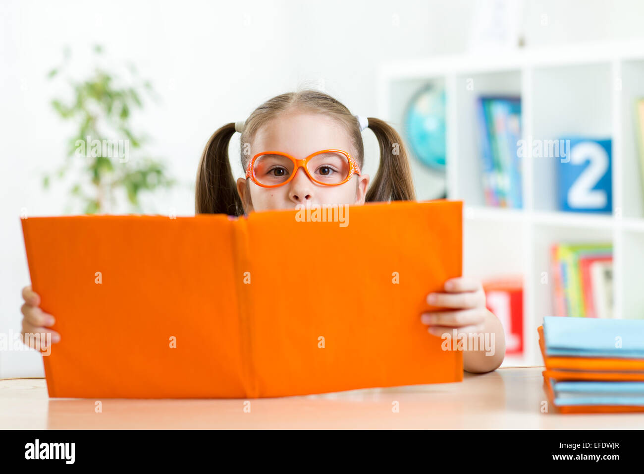 child at the table with books Stock Photo - Alamy