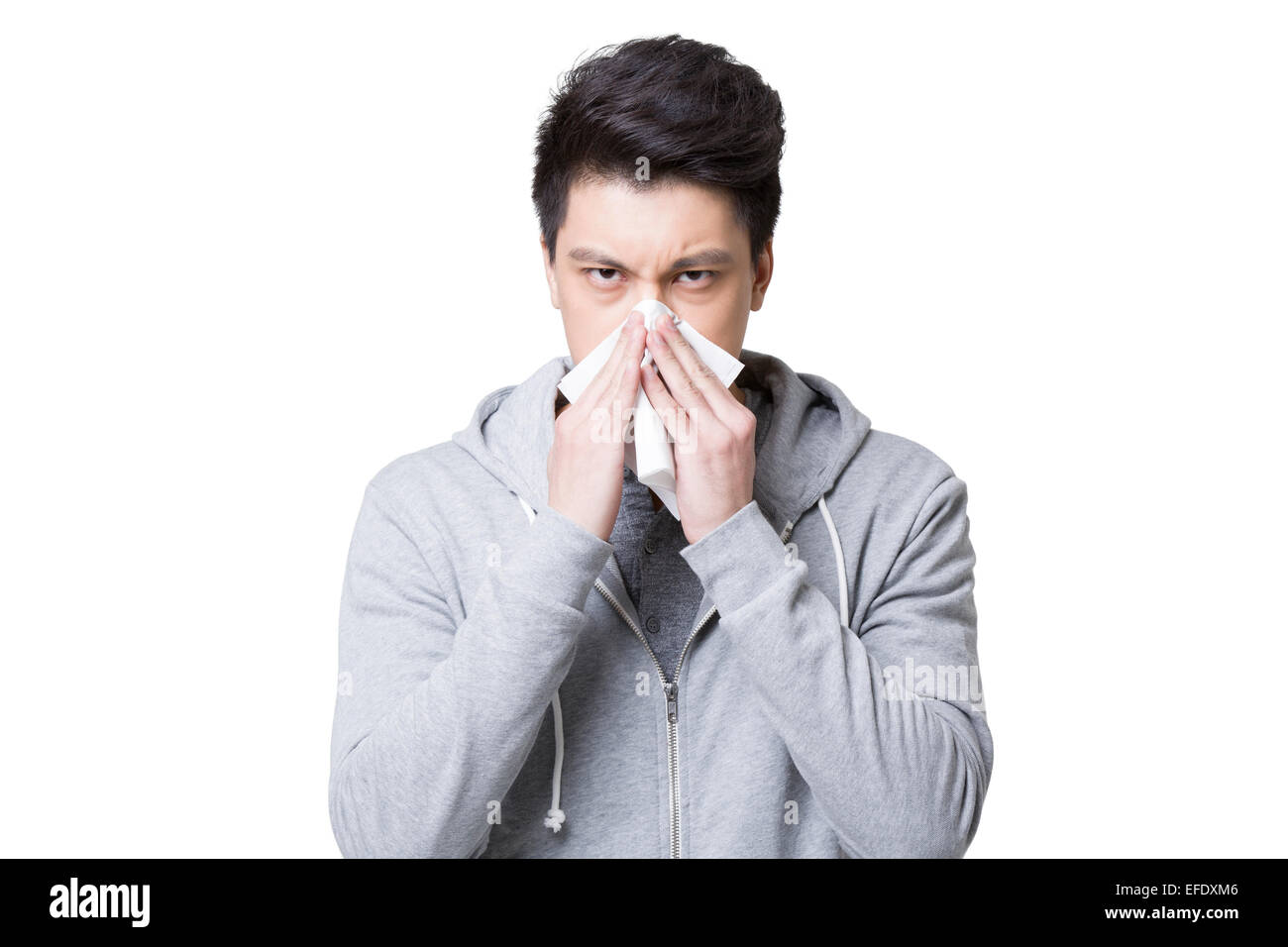 Young man blowing nose Stock Photo - Alamy