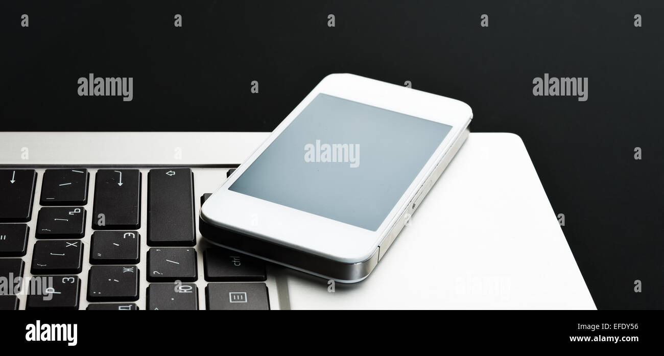 keyboard with phone on black background Stock Photo - Alamy