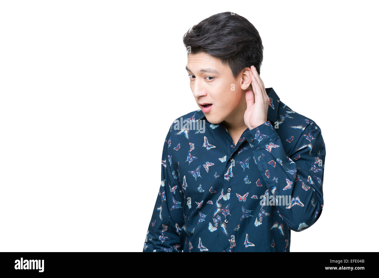 Young man cupping ear to listen Stock Photo - Alamy