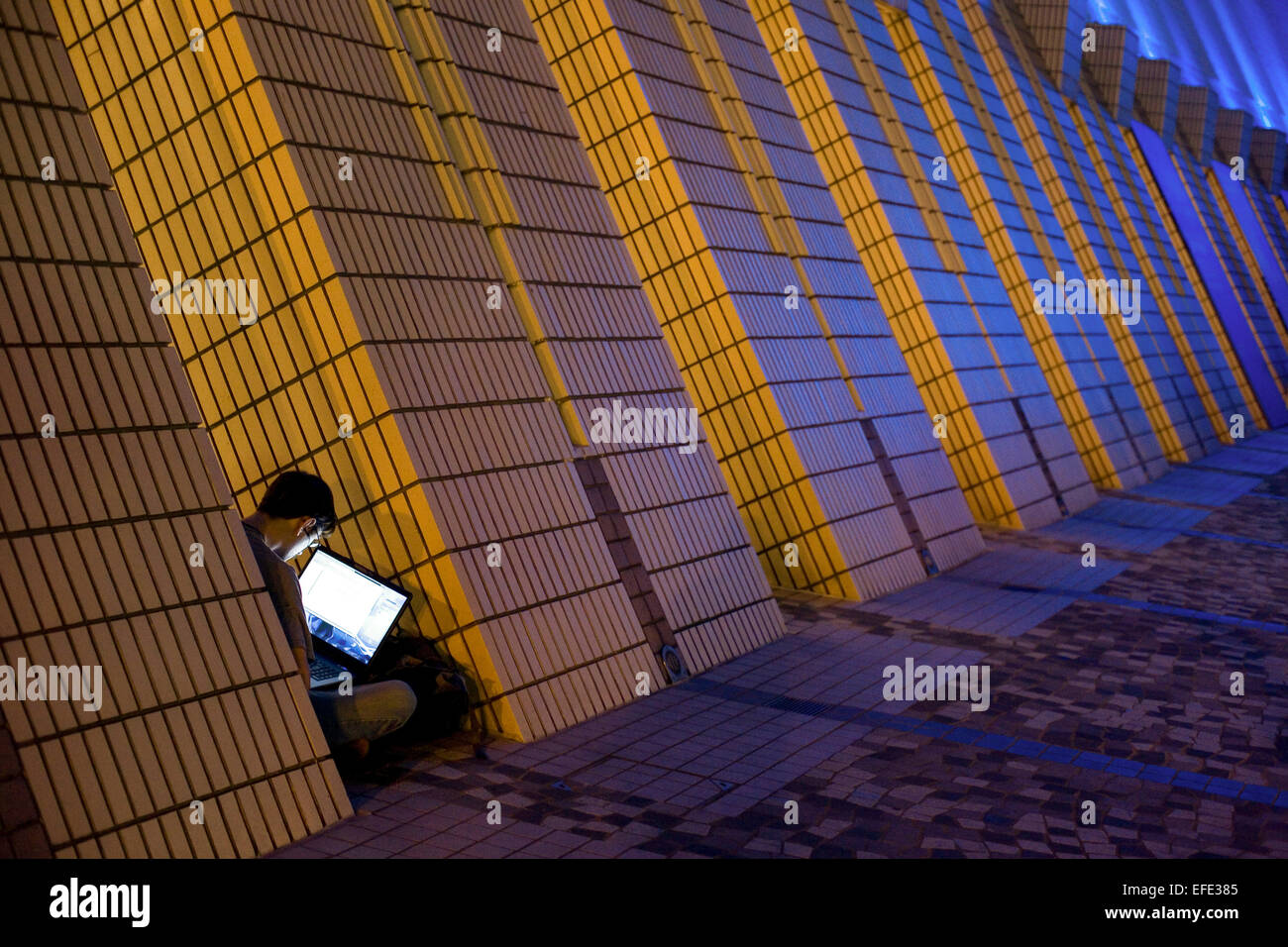 Student with computer studying in public place Stock Photo - Alamy
