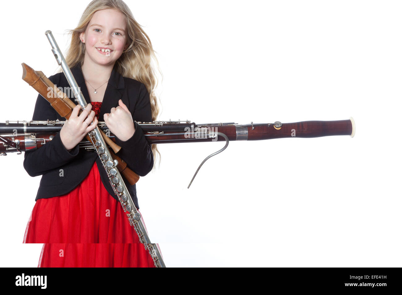 young blond girl holds woodwind instruments in studio against white ...
