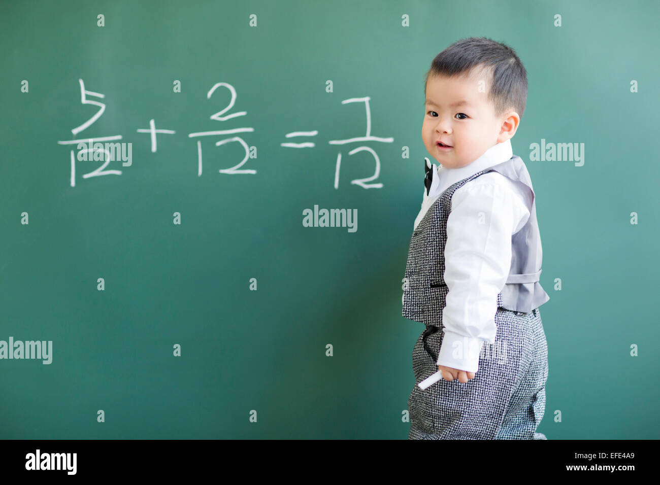 Cute baby doing mathematics on blackboard Stock Photo - Alamy