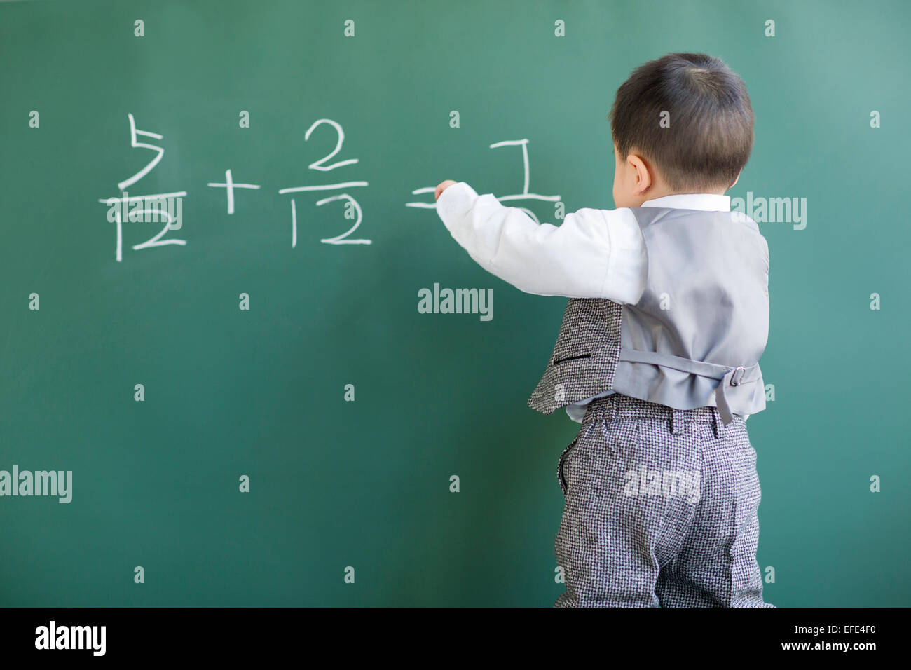 Cute baby doing mathematics on blackboard Stock Photo - Alamy