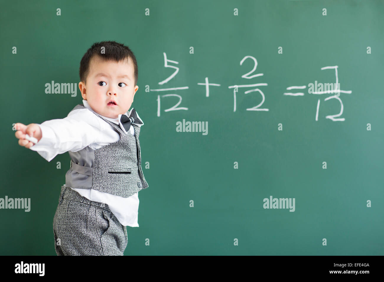 Cute baby doing mathematics on blackboard Stock Photo - Alamy