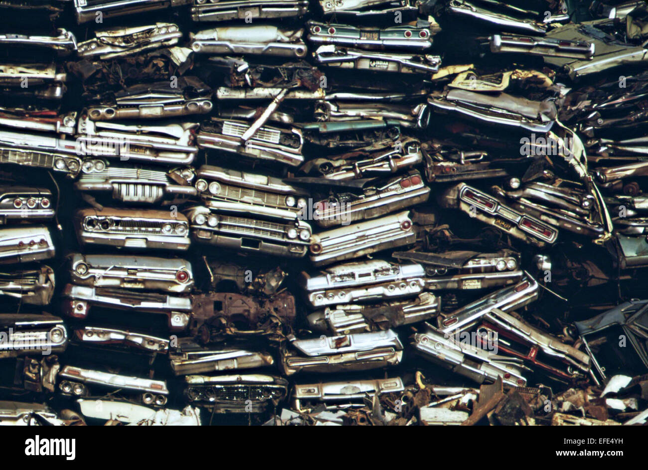 Junked automobiles stacked in a junkyard crushed for use as scrap metal ...