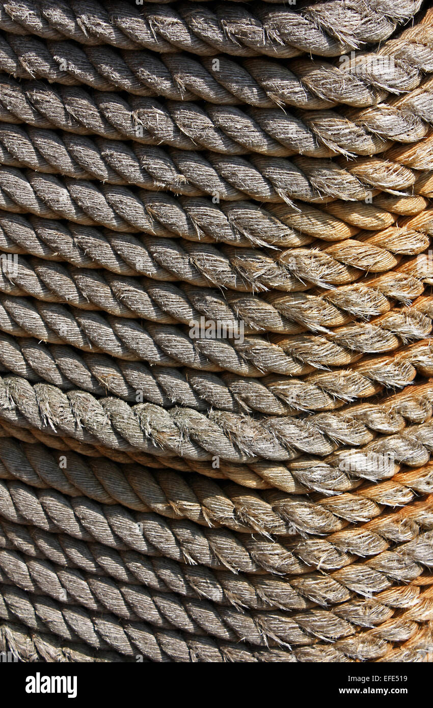 Tightly coiled tan and brown rope in straight lines on a sunny day ...