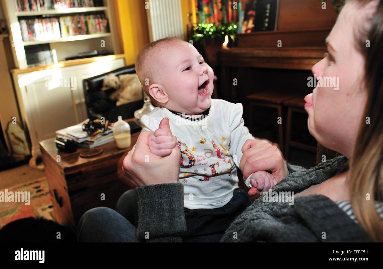 A mother and her four month old baby interacting together through touch ...