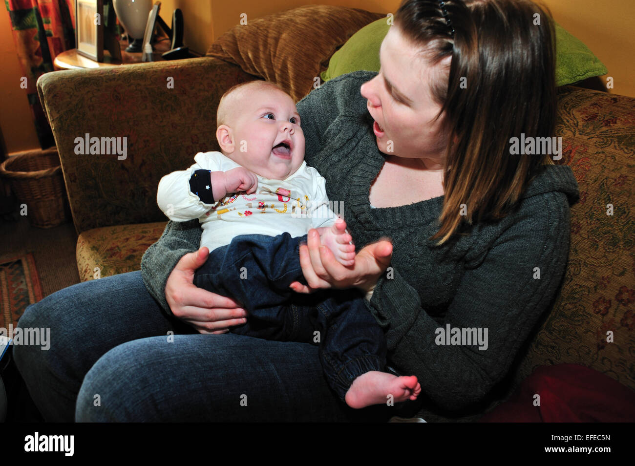 A mother and her four month old baby interacting together through touch ...