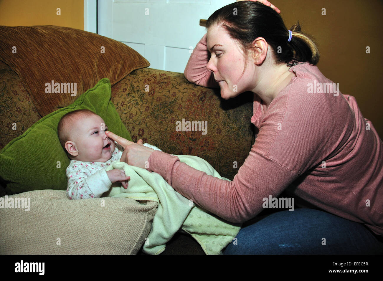 A mother and her four month old baby interacting together through touch ...
