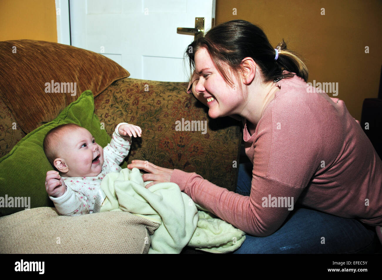 A mother and her four month old baby interacting together through touch ...