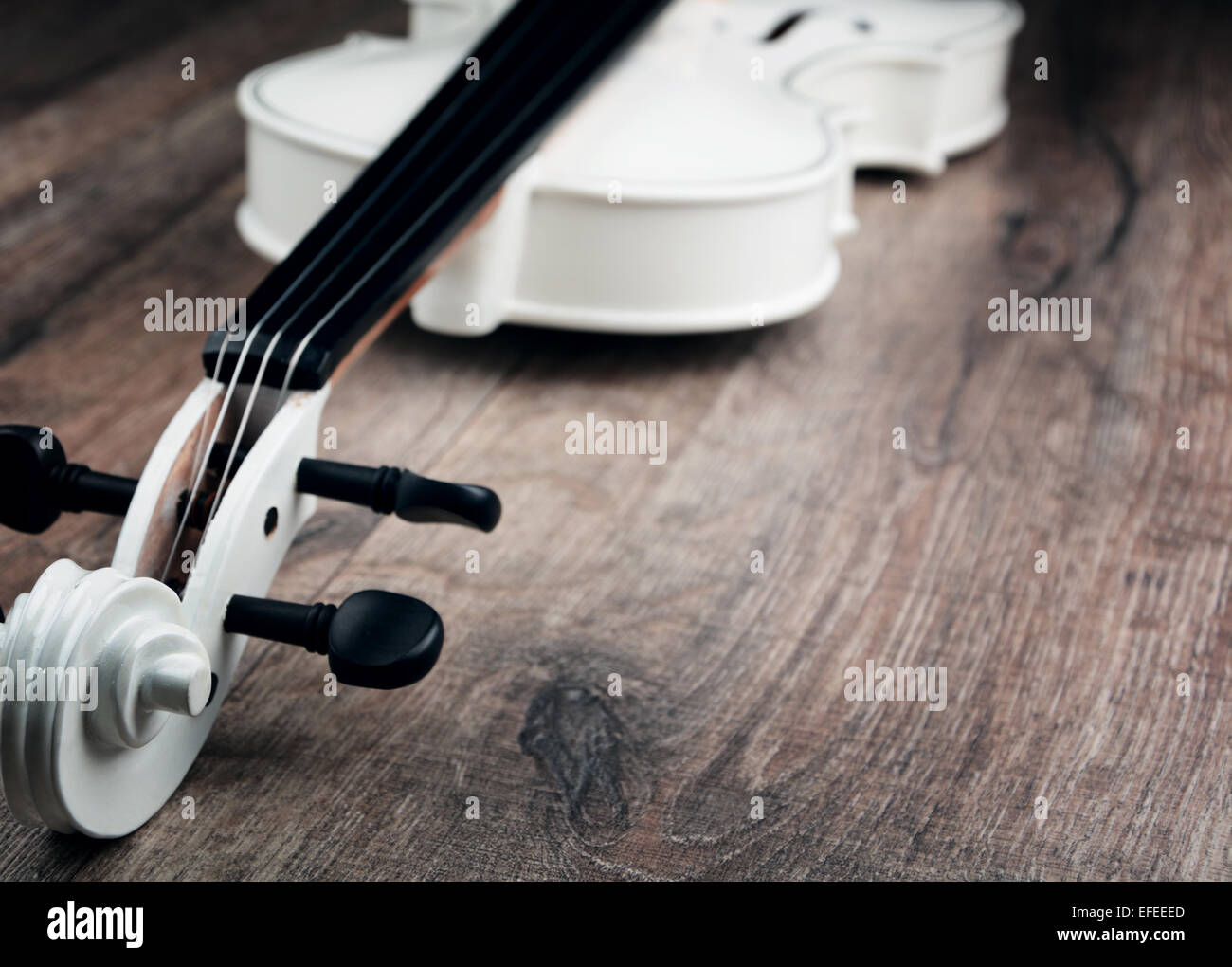Beautiful white violin on the wooden table Stock Photo - Alamy