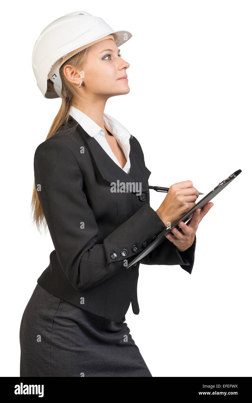 Businesswoman wearing hard hat, writing on clipboard Stock Photo - Alamy