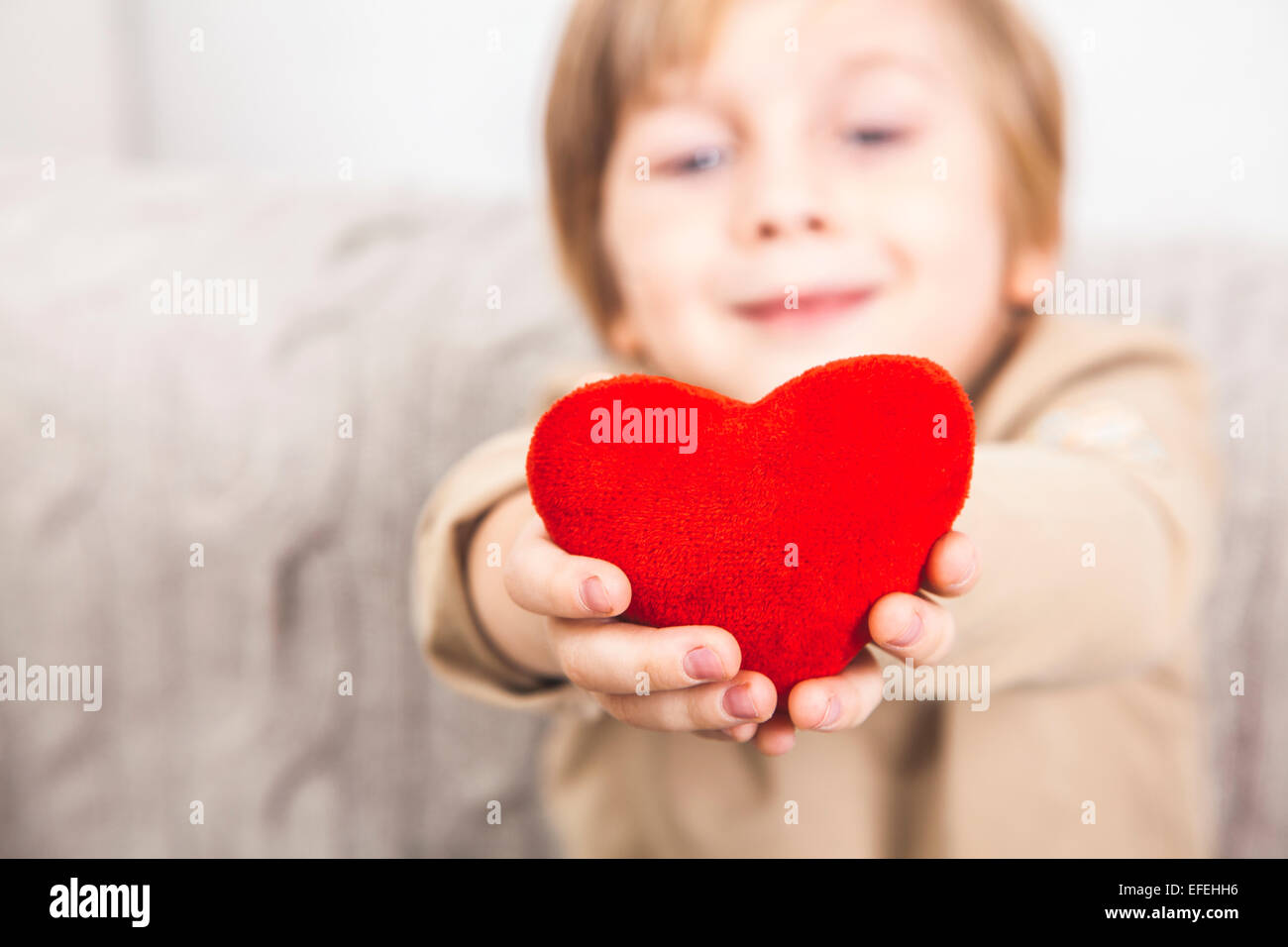 Cute young boy with a red heart in his hands Stock Photo - Alamy