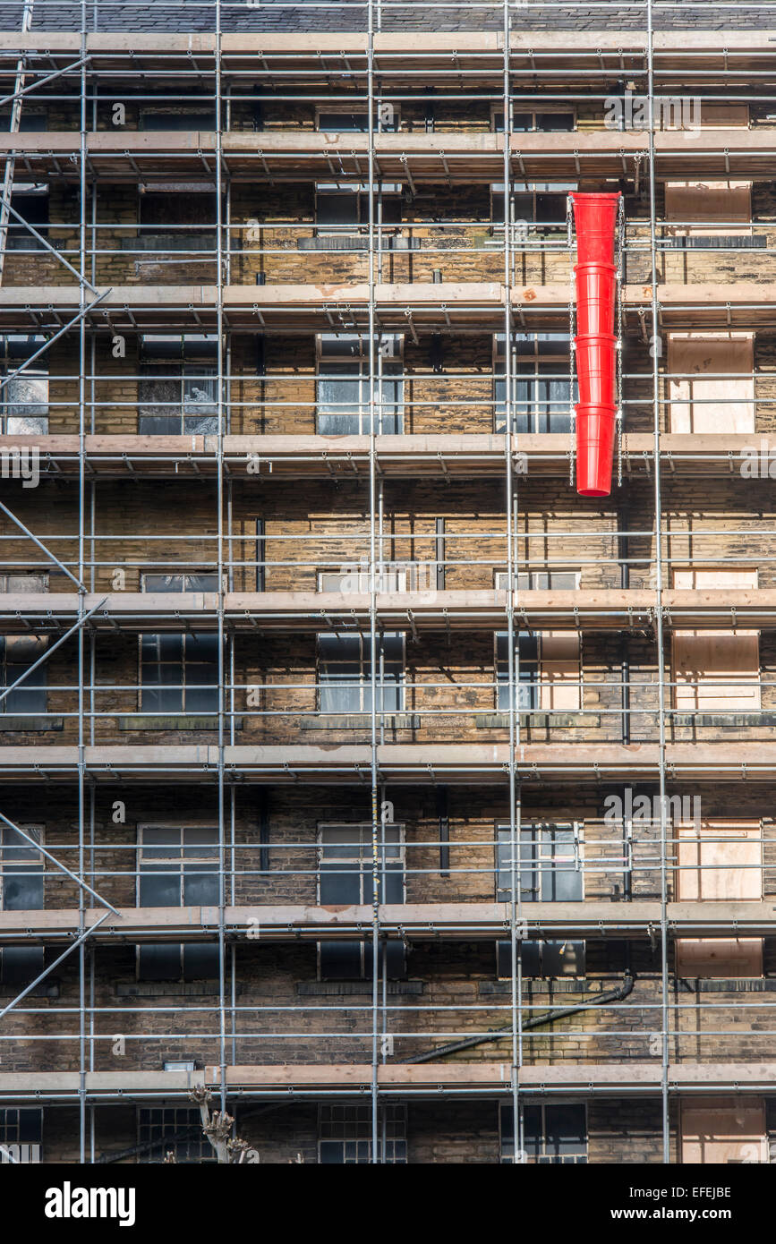 Red waste chute attached to steel scaffolding Stock Photo - Alamy