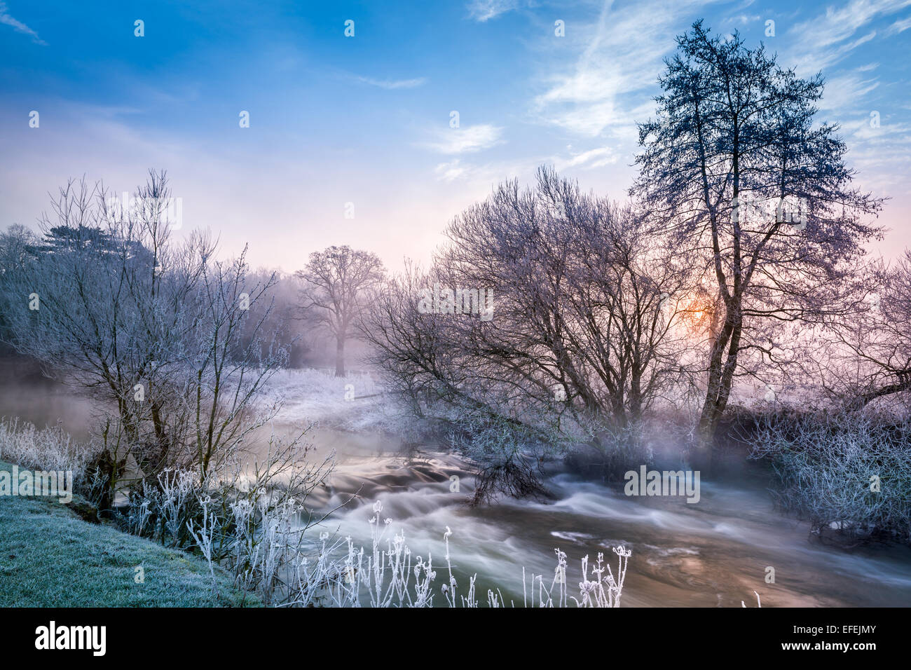 The sun rises above the mist to light up a weir pool on the river Avon ...